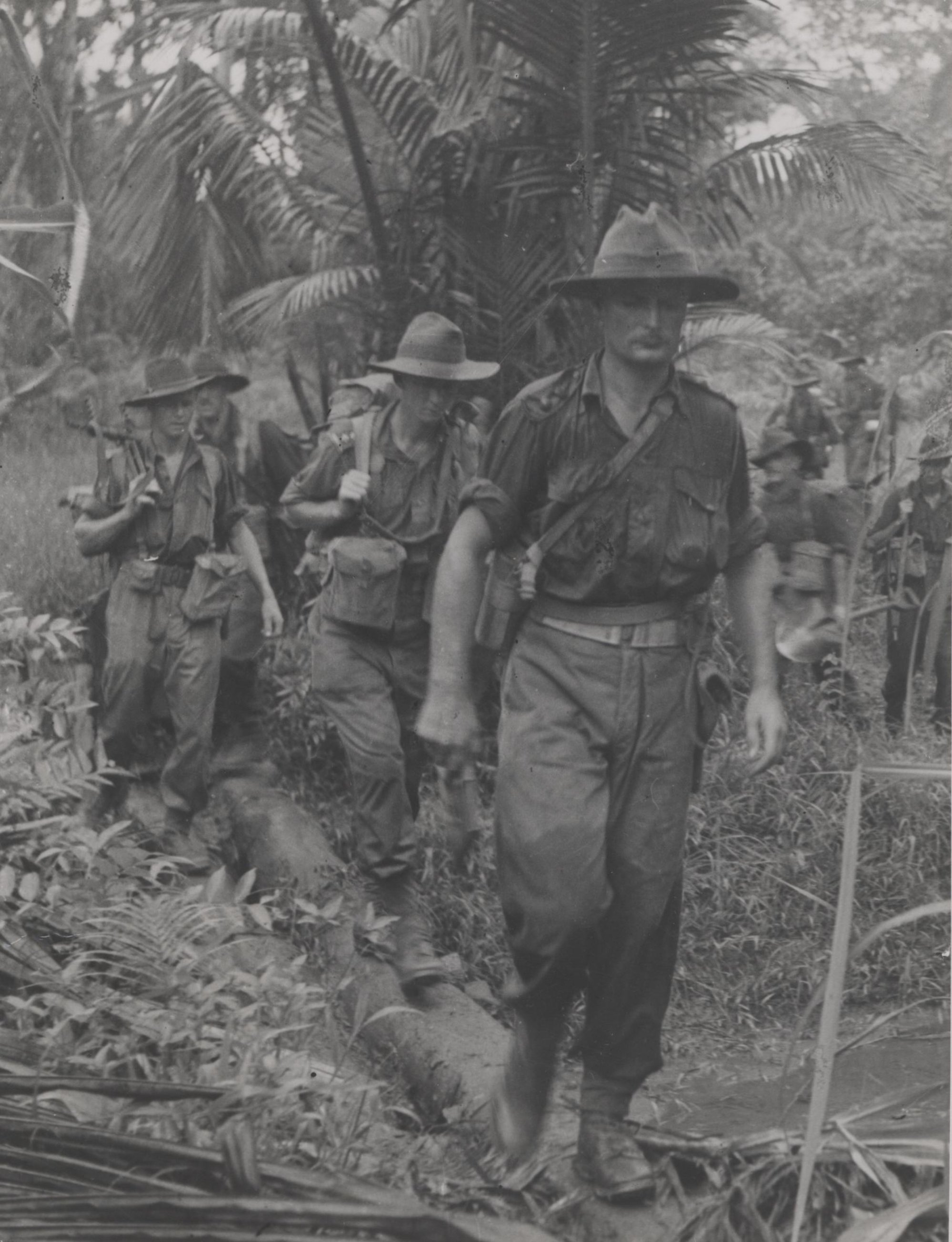 Australian soldiers crossing fallen logs over a creek, Aitape, New ...