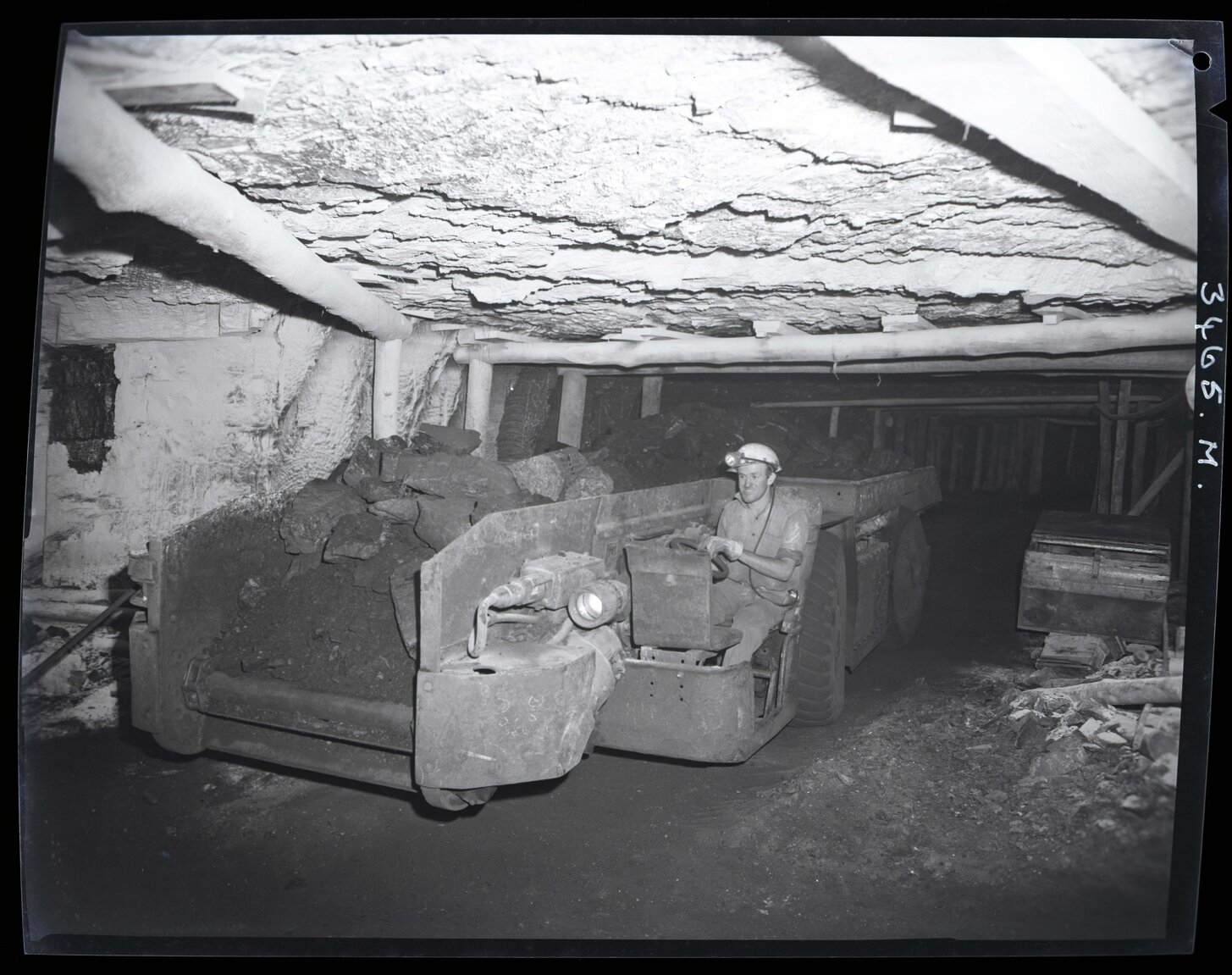 Man underground transporting coal in a shuttle car, 1963 | Living Histories
